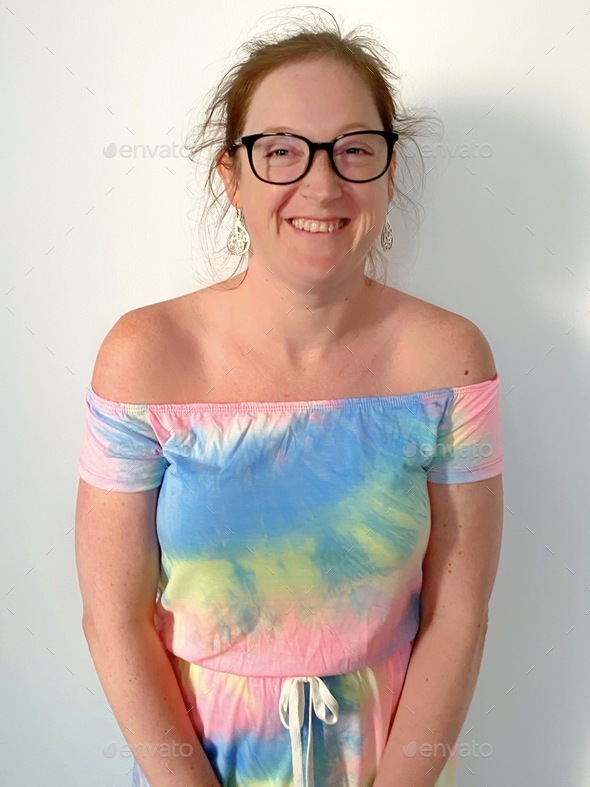 Smiling young millennial woman wearing a colorful jumpsuit and a ...