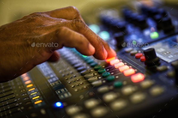 Unrecognizable diverse male recording engineer at his soundboard making ...
