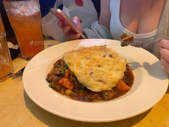 Millennial woman eats Shepherd’s Pie at a local restaurant after ...