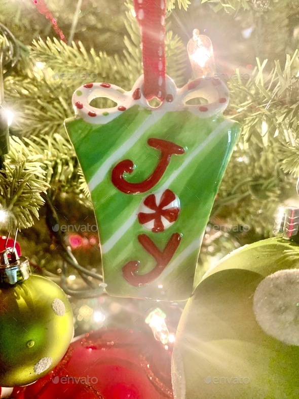 Christmas ornament on a Christmas tree that says joy with lights Stock ...