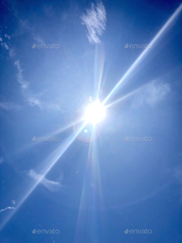 Sun shining bright up on the blue sky with shooting sun rays. Stock ...