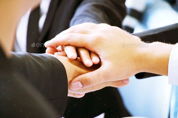 Hand of team work hand in hand together. Stock Photo by Thanineech