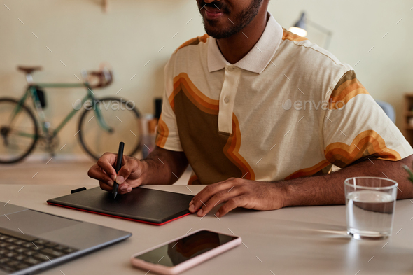 Creative black man using pen tablet Stock Photo by seventyfourimages