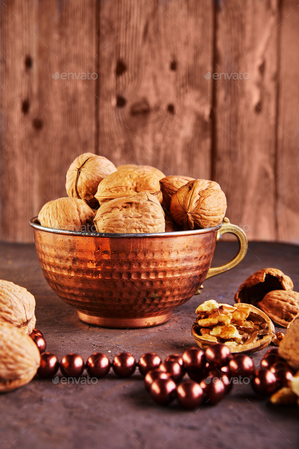 Walnuts in a tin cup, whole and finely chopped, next to the filling and ...