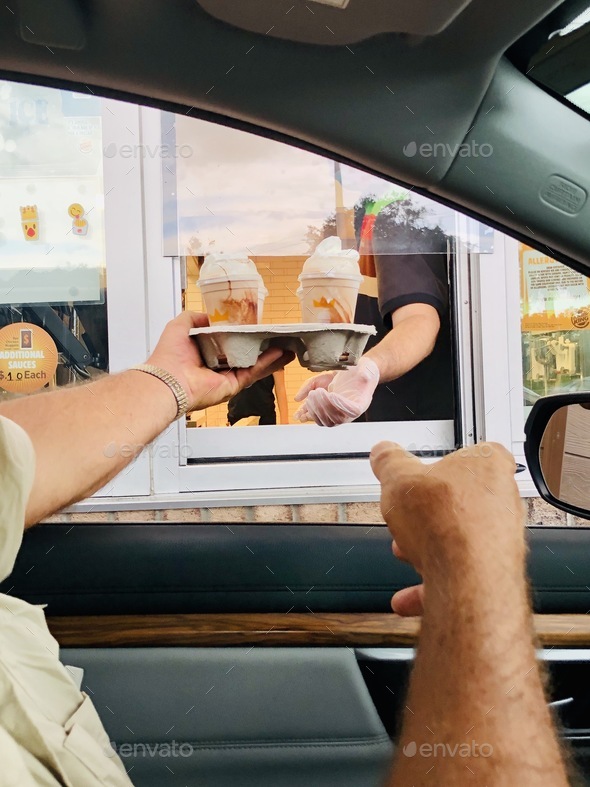 Driver at the drive through window picking up his Order. Stock Photo by ...