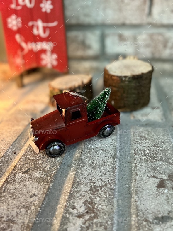 Little red truck carrying a Christmas tree. Stock Photo by marisap7