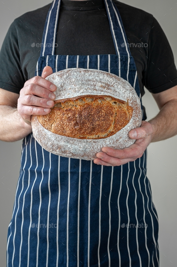 Close-up at bakers hands holding organic loaf of sourdough bread in ...