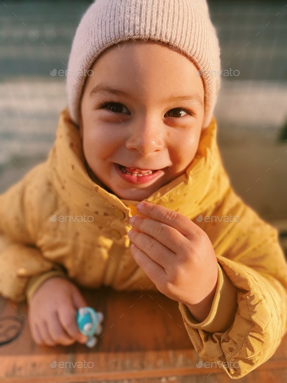 Close up happy portrait of preschool kid, cold weather, sunny fall day ...