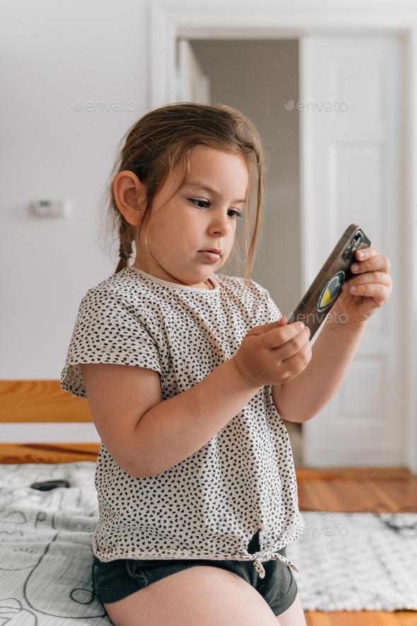 Preschool child using phone at home. Stock Photo by troyanpx | PhotoDune
