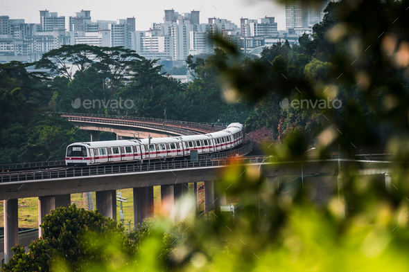 A Mass Rapid Transit (MRT) train making its way around a bend through ...