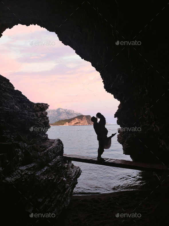 Shadow of a couple in a cave. Man is holding woman in his arms ...