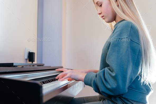 A young girl pressing piano keys Stock Photo by Marinesea | PhotoDune