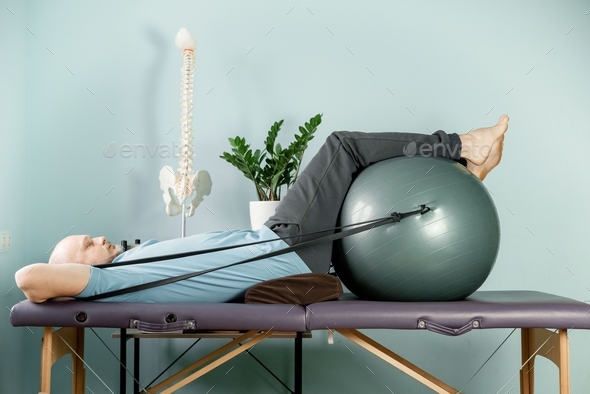 Rotation exercises on the fitness ball with resistance bands in ...