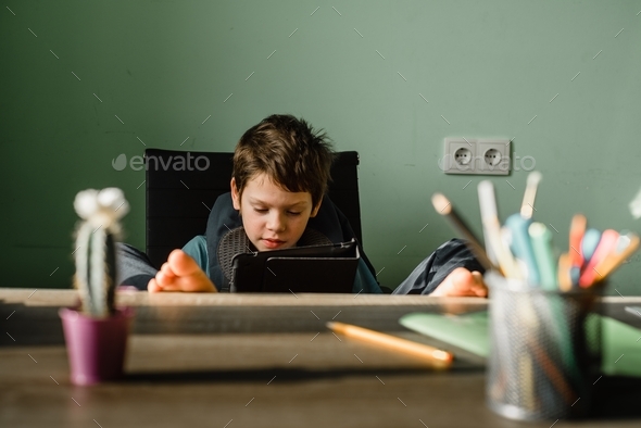 Junior school boy using tablet at home, growing up with technology ...