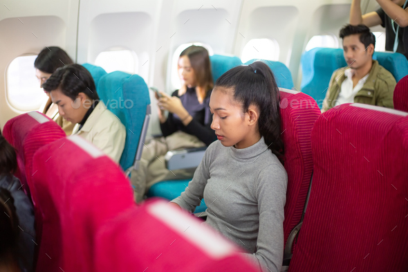 Group of passengers sitting at seat on airplane during flight. Stock ...