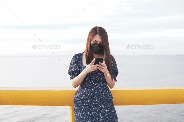 women use social media by smartphone in outdoor with the sea background ...
