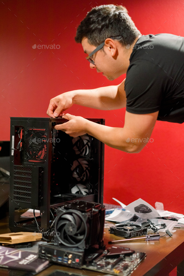 Man building a pc on a red basement Stock Photo by takemewu31 | PhotoDune