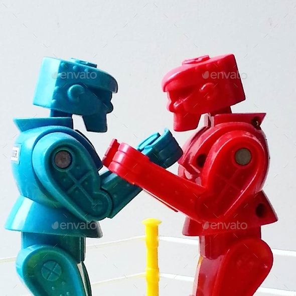 Side view of red and blue toy boxing figures against white background ...