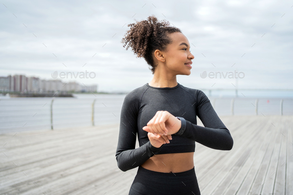 Uses a fitness bracelet tracker watch on her arm, a sporty woman does a ...