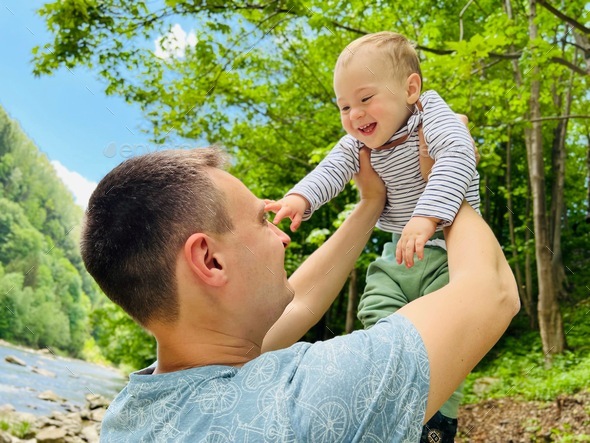 A happy father raises his son above himself. Family concept. Spending ...