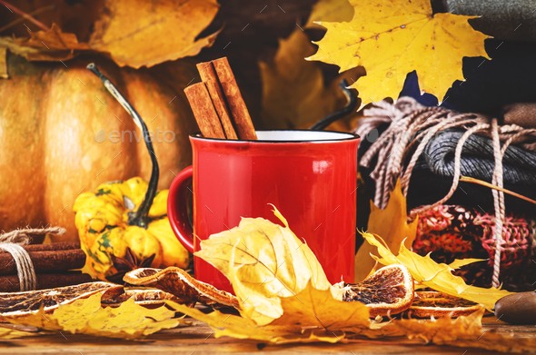 Autumn hot drink in red cup on fall background with pumpkins, fallen ...