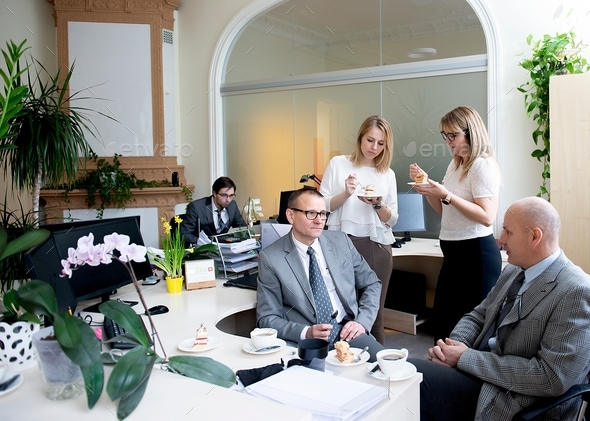 Colleagues having a coffee break in the office at their work desk Stock ...