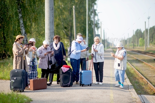 Group of positive senior elderly people travelers using tablets and ...