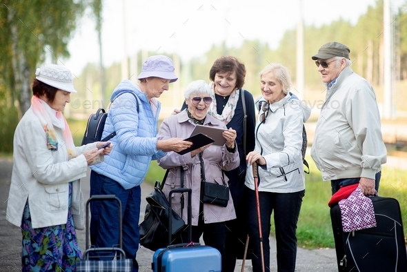 Group of positive senior elderly people looking at digital map on ...