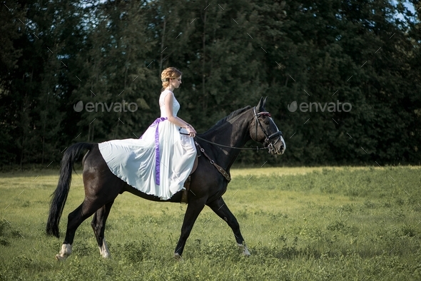 Beautiful and stunning bride, riding a horse in the nature, on her ...