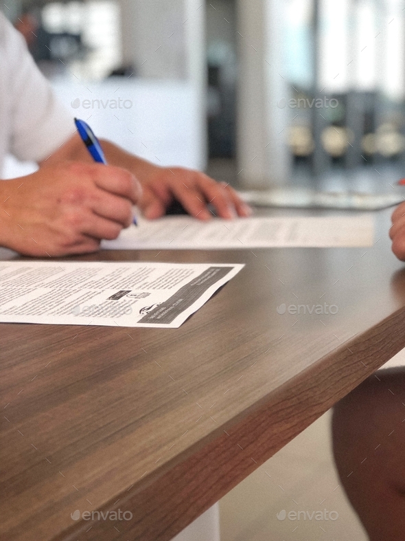 People signing documents at desk in office Stock Photo by Mrskiac