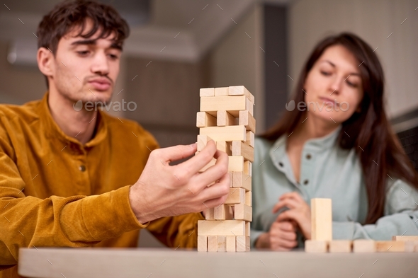 Board game and people leisure concept. couple playing Jenga blocks at ...