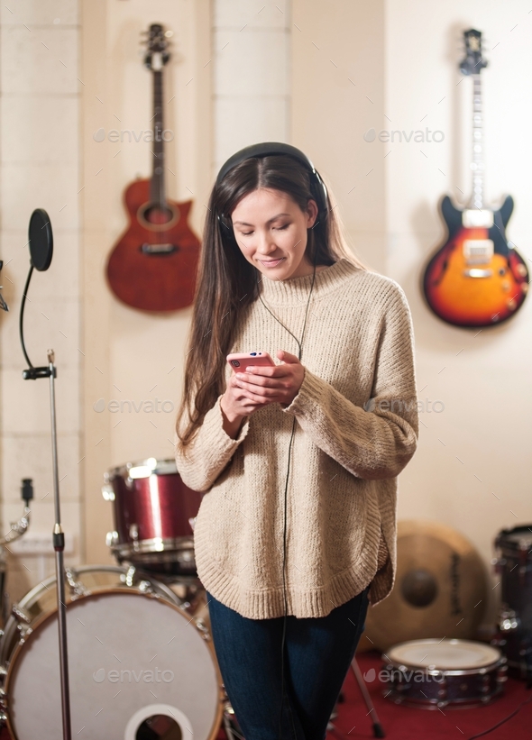 Young girl singer records vocals in a professional recording studio ...