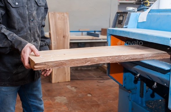 Male carpenter planing wood on a lathe in a carpentry workshop Stock ...