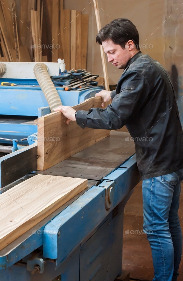 Male carpenter planing wood on a lathe in a carpentry workshop Stock ...