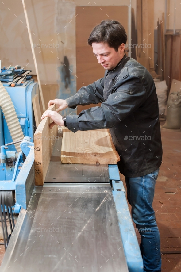 Male carpenter planing wood on a lathe in a carpentry workshop Stock ...