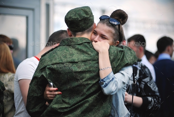 Young sad girl hugs and says goodbye to a soldier on the street Stock ...