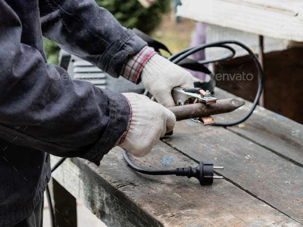 The man is connecting a welding machine. It clamps the metal with a ...