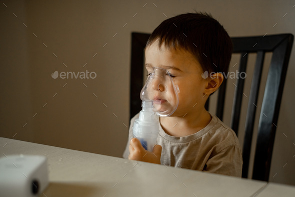 The little boy is sick. The child does inhalations Stock Photo by nastuffa