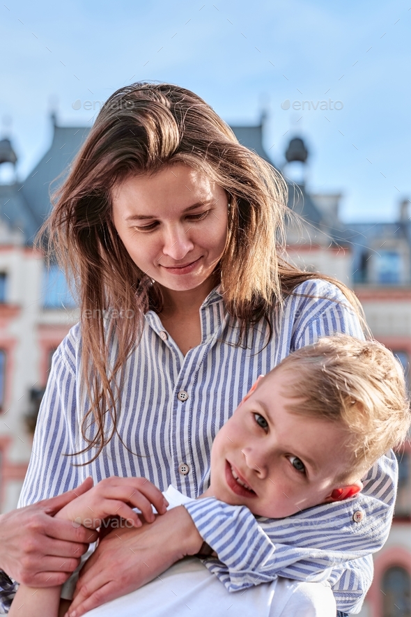 Happy woman and child embrace each other on a summer sunny day. Happy ...