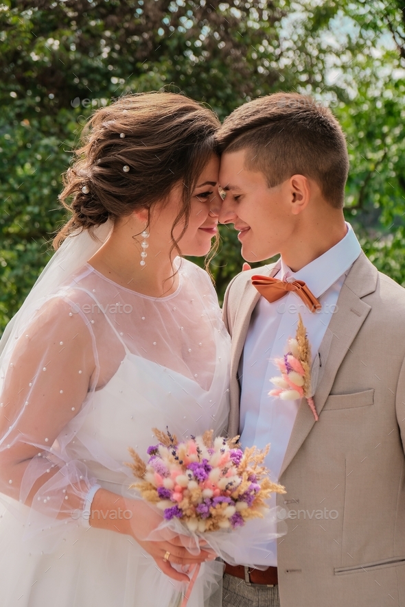 Faces happy newlyweds in the pofil. The bride and groom gently look at ...