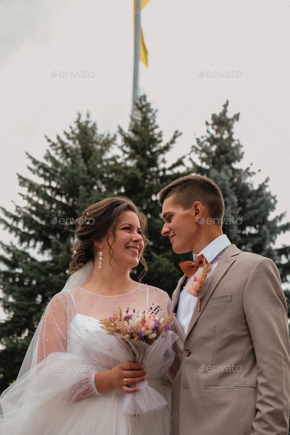 Faces happy newlyweds in the pofil. The bride and groom gently look at ...