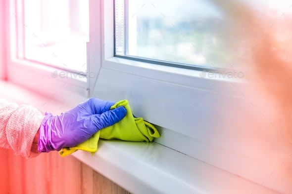 Cleaning the windowsill wiping dust by blue microfiber cloth for ...