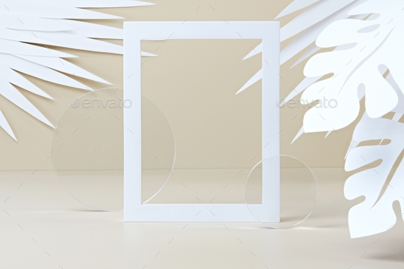 beige scene with empty frame and paper cut leaves Stock Photo by ganjalex