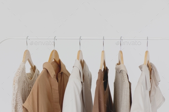 Clothing rack with clothes on white background. Stock Photo by Ablozhka