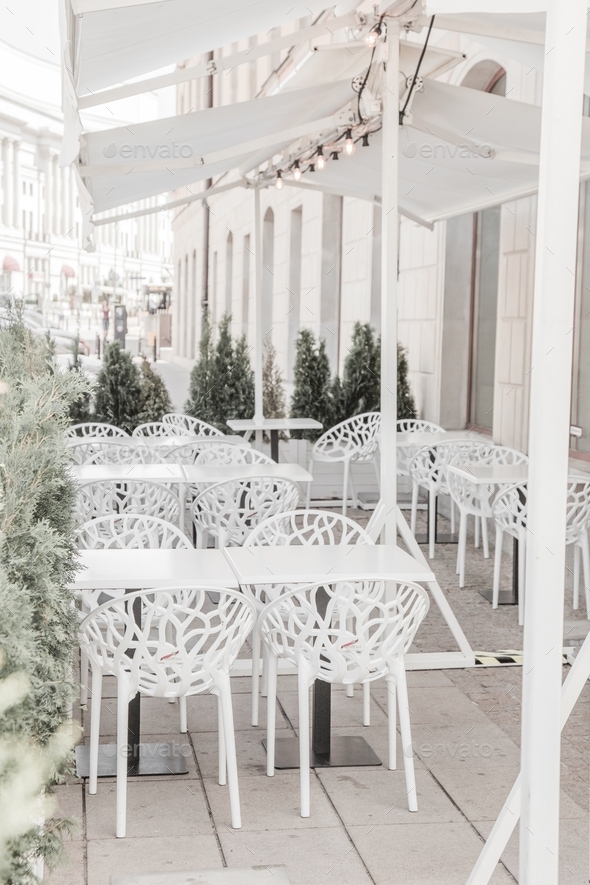 Empty street cafe. White chairs and tables. City restaurant. Without ...