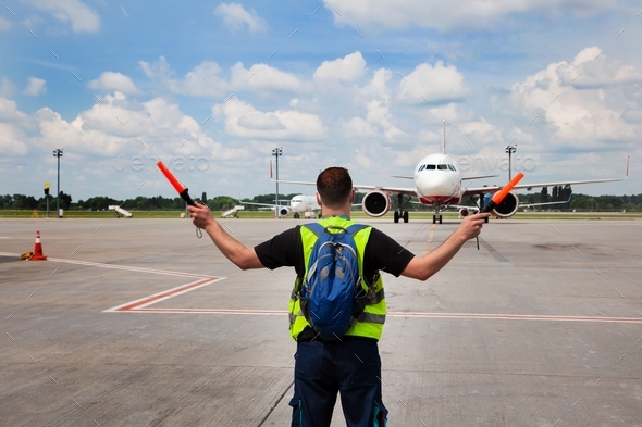 Air traffic controller at the airport. The man salutes and guides the ...