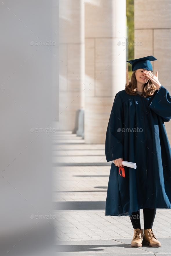 White middle-aged woman in blue gown and cap crying with joy after ...