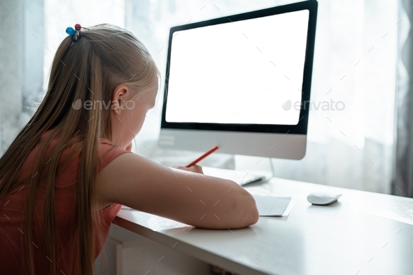 Young blonde tween girl doing homework. Mockup computer. Back to school ...