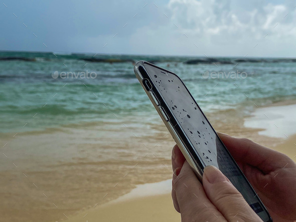 Using a mobile phone at the beach Stock Photo by Dobbidodarr | PhotoDune