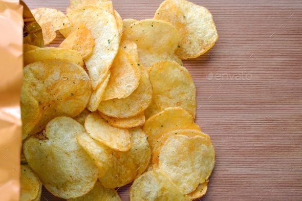 Potato crisps or potato chips spilling out of the package. Stock Photo ...